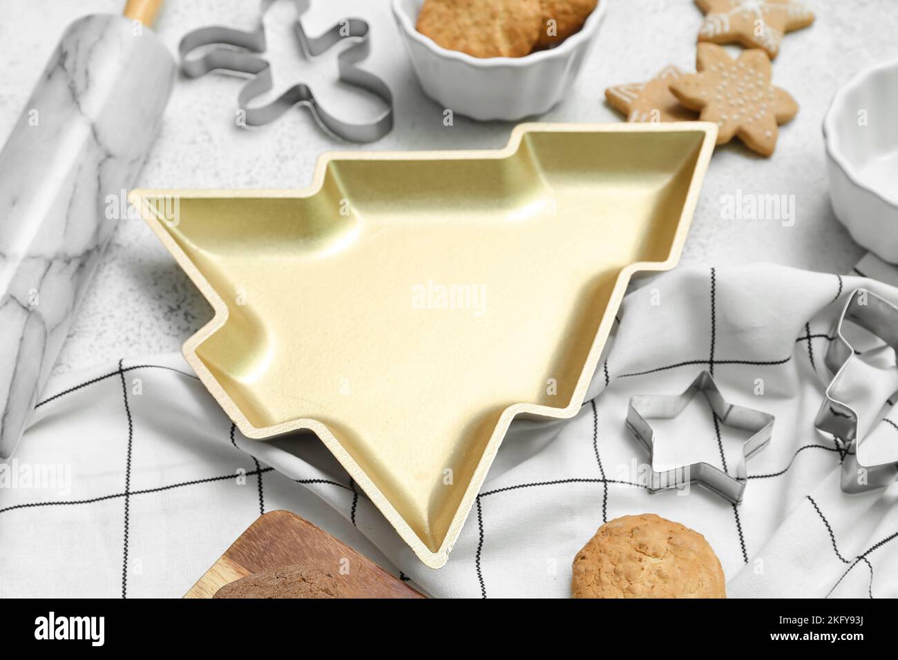 Plate in shape of Christmas tree with cookies, cutters and napkin on ...
