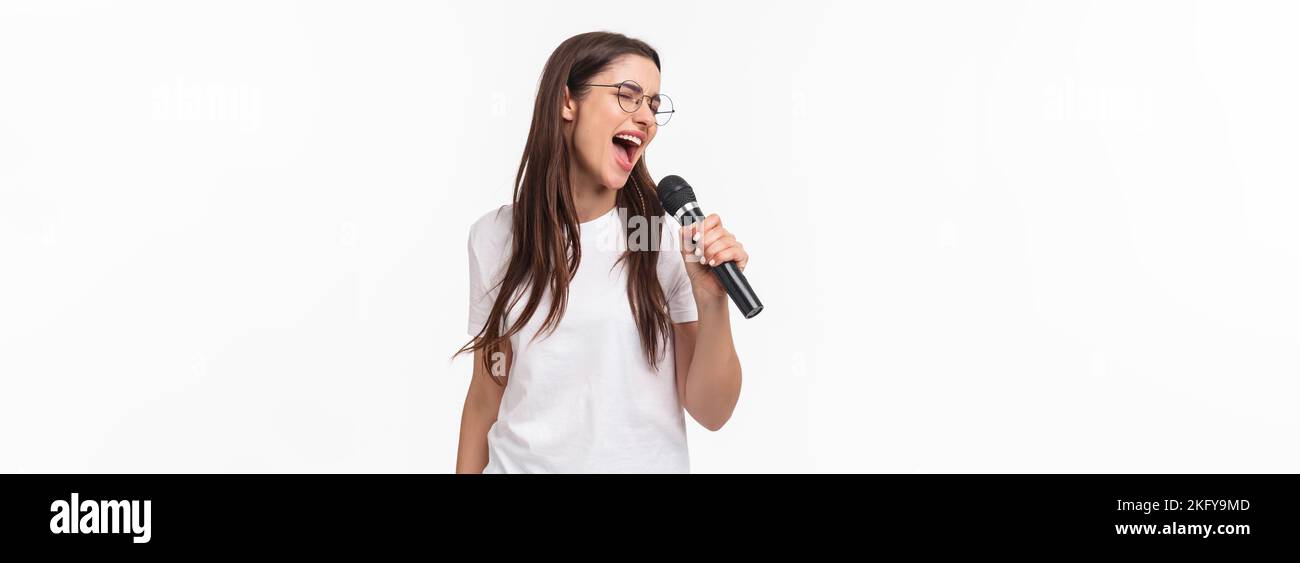 Carefree happy and relaxed young woman singing her heart out ...