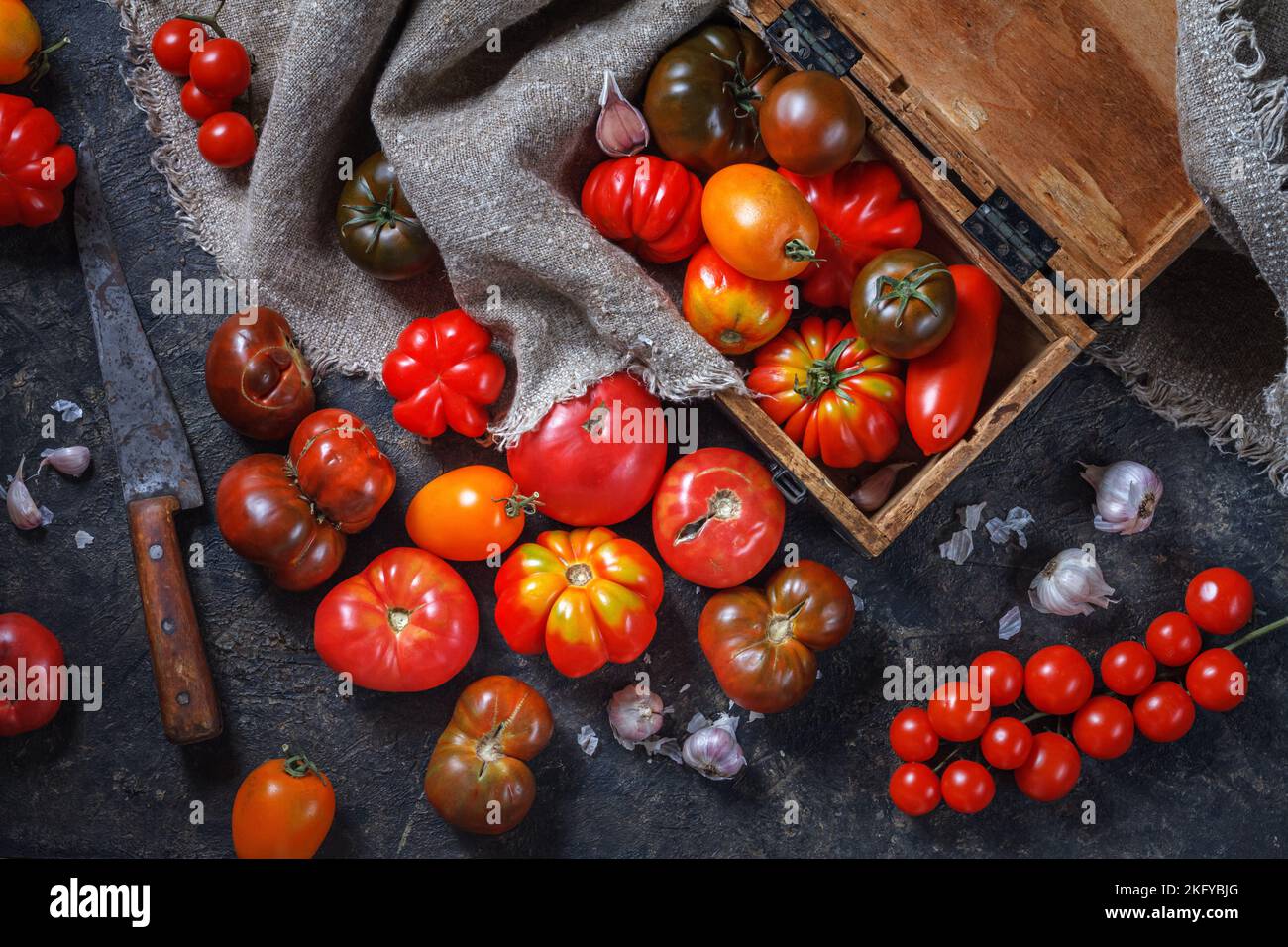 Many different breeds, shapes and sizes of tomatoes in an old wooden ...
