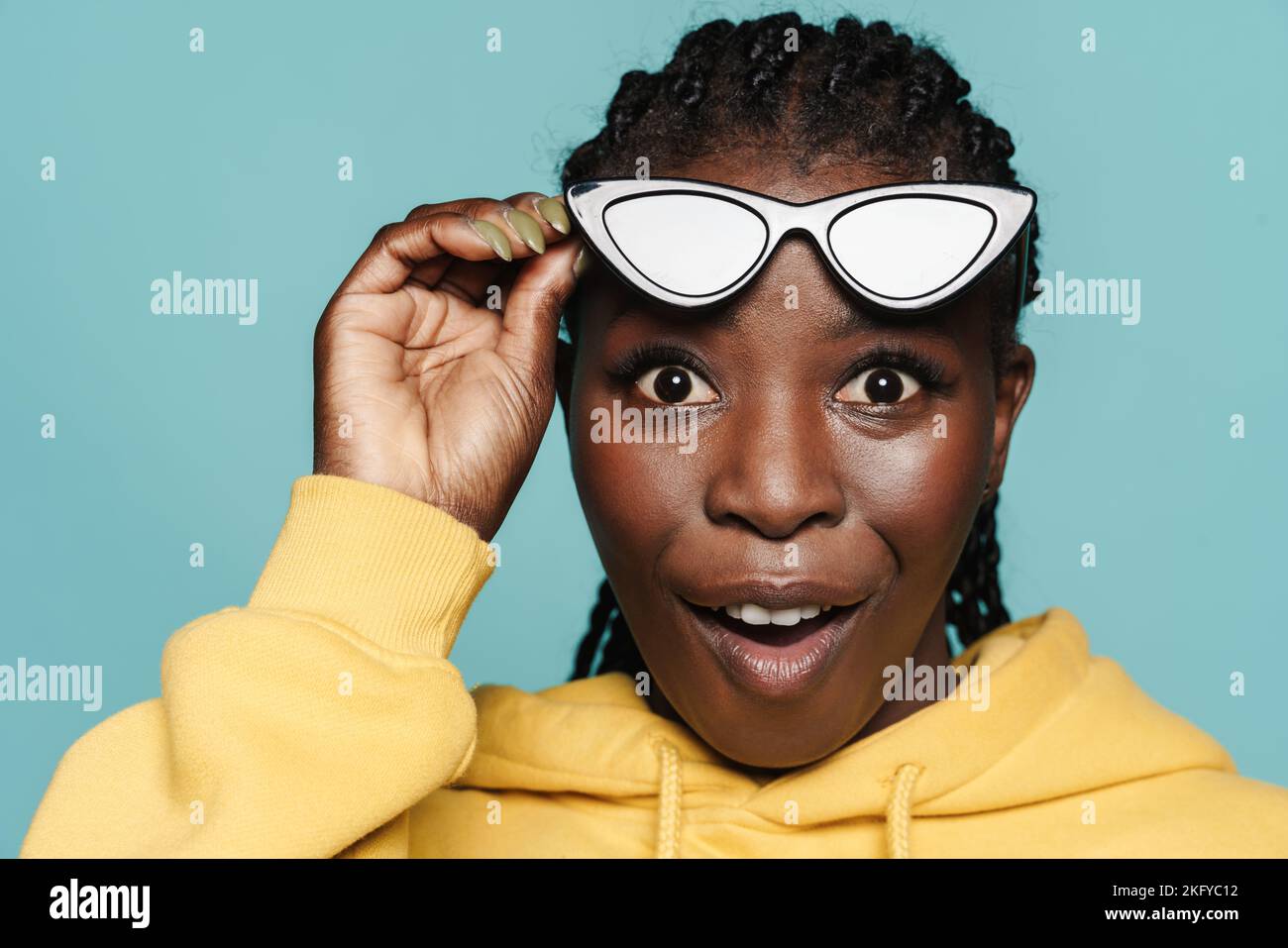 Young Black Woman Wearing Sunglasses Expressing Surprise At Camera