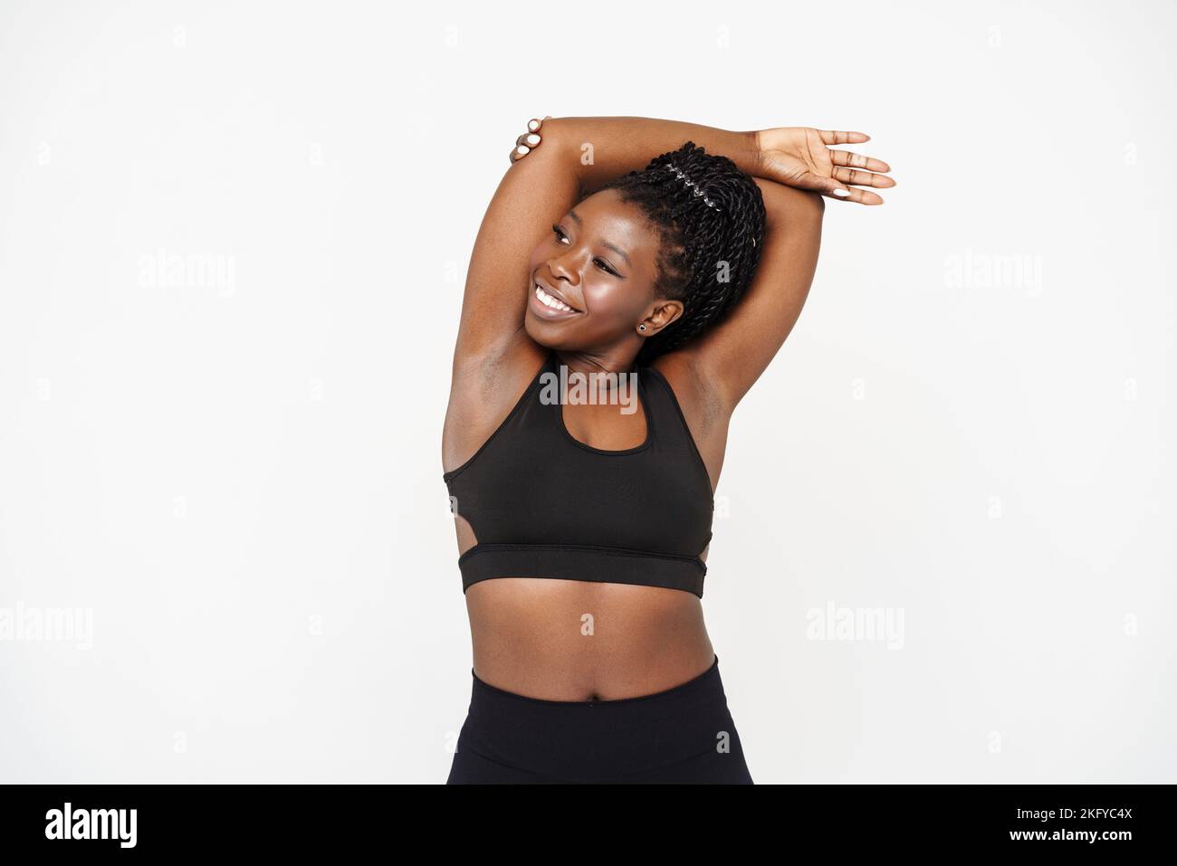 Black young woman doing exercise while working out isolated over white ...