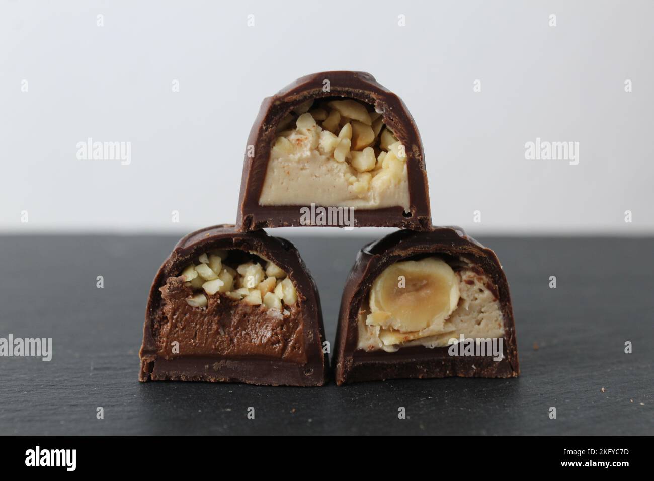 three chocolate glazed case candies with praline chocolate filling and ...