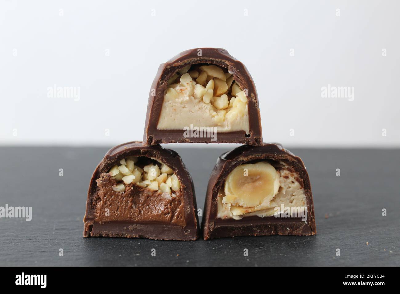 three chocolate glazed case candies with praline chocolate filling and ...