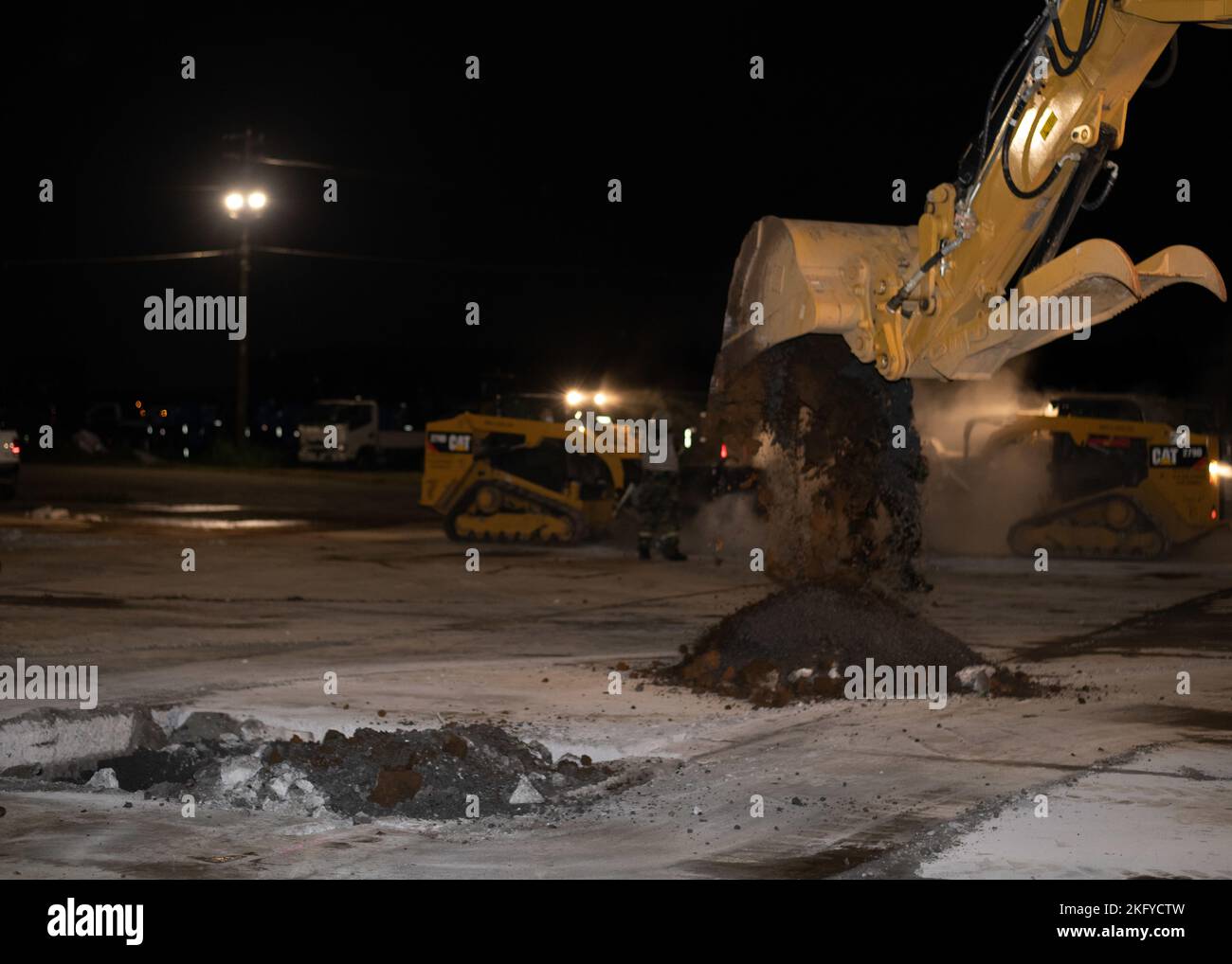 A 374th Civil Engineer Squadron Airman uses an excavator to scoop out ...