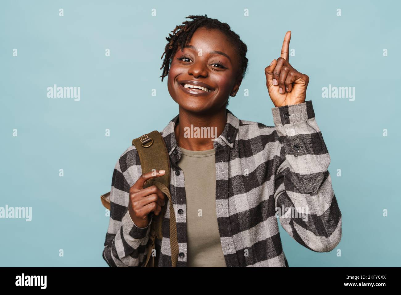 African american young woman wearing plaid shirt and backpack gesturing ...