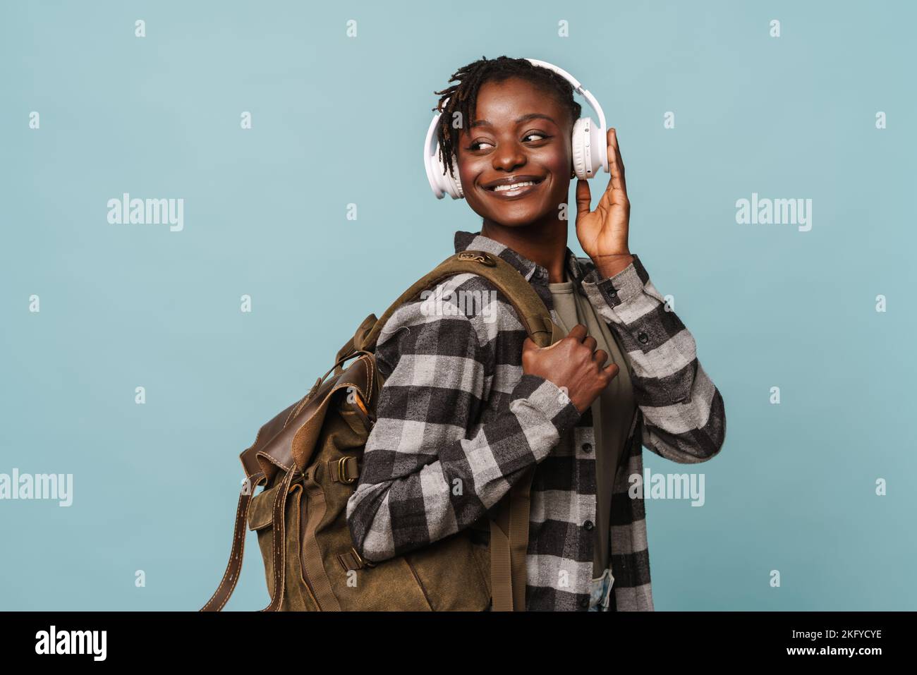 African american young woman in plaid shirt and backpack using ...