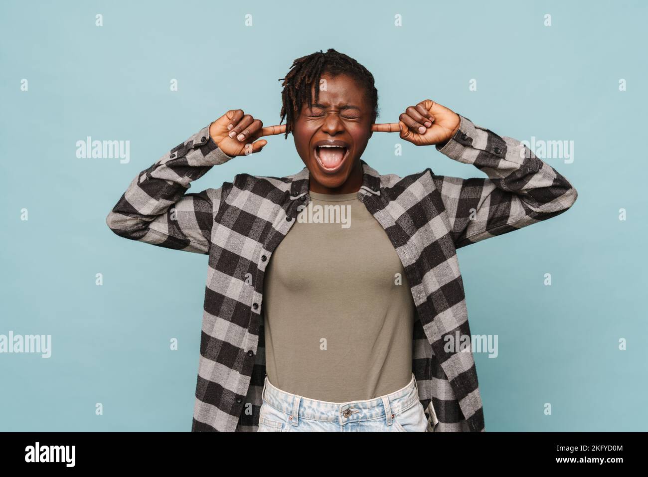 African american upset woman screaming and plugging her ears isolated ...