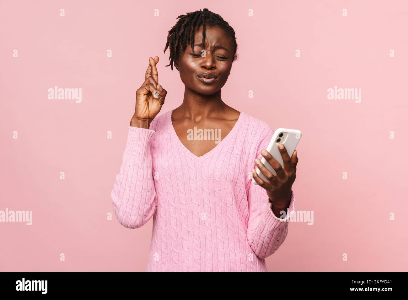 Black woman making gesture for good luck while using mobile phone ...