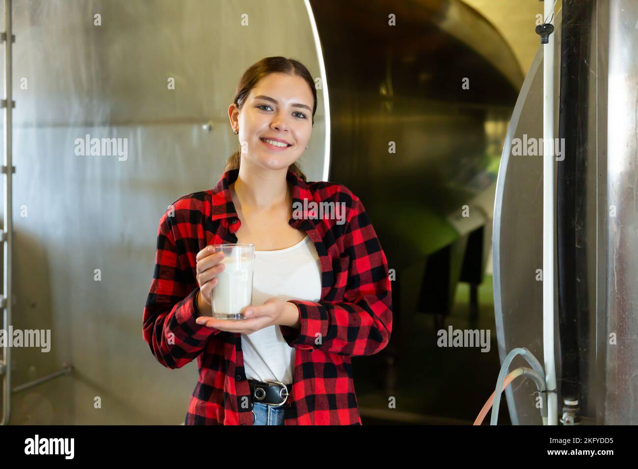 Female milker posing with glass of milk on dairy farm Stock Photo - Alamy