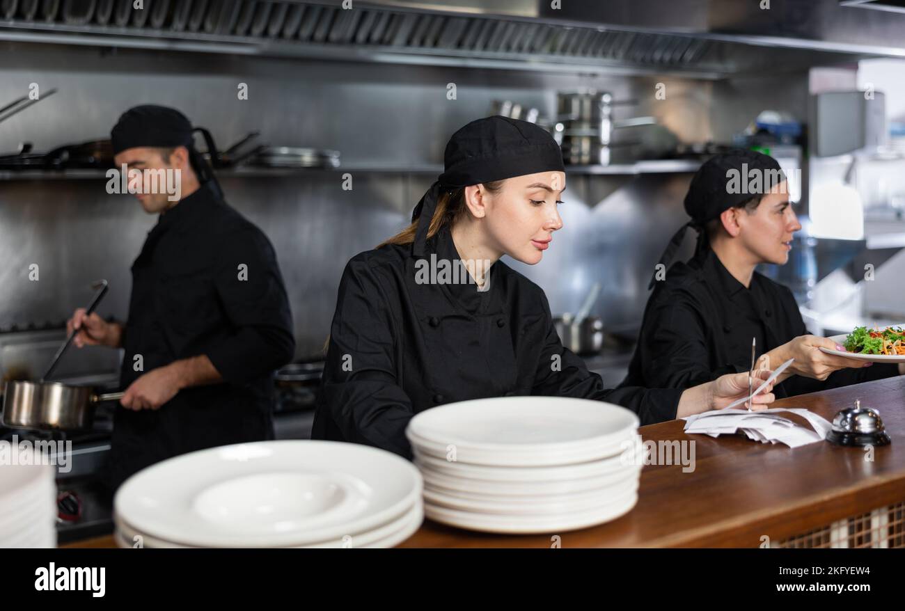 Chef checking orders and giving out salad Stock Photo - Alamy