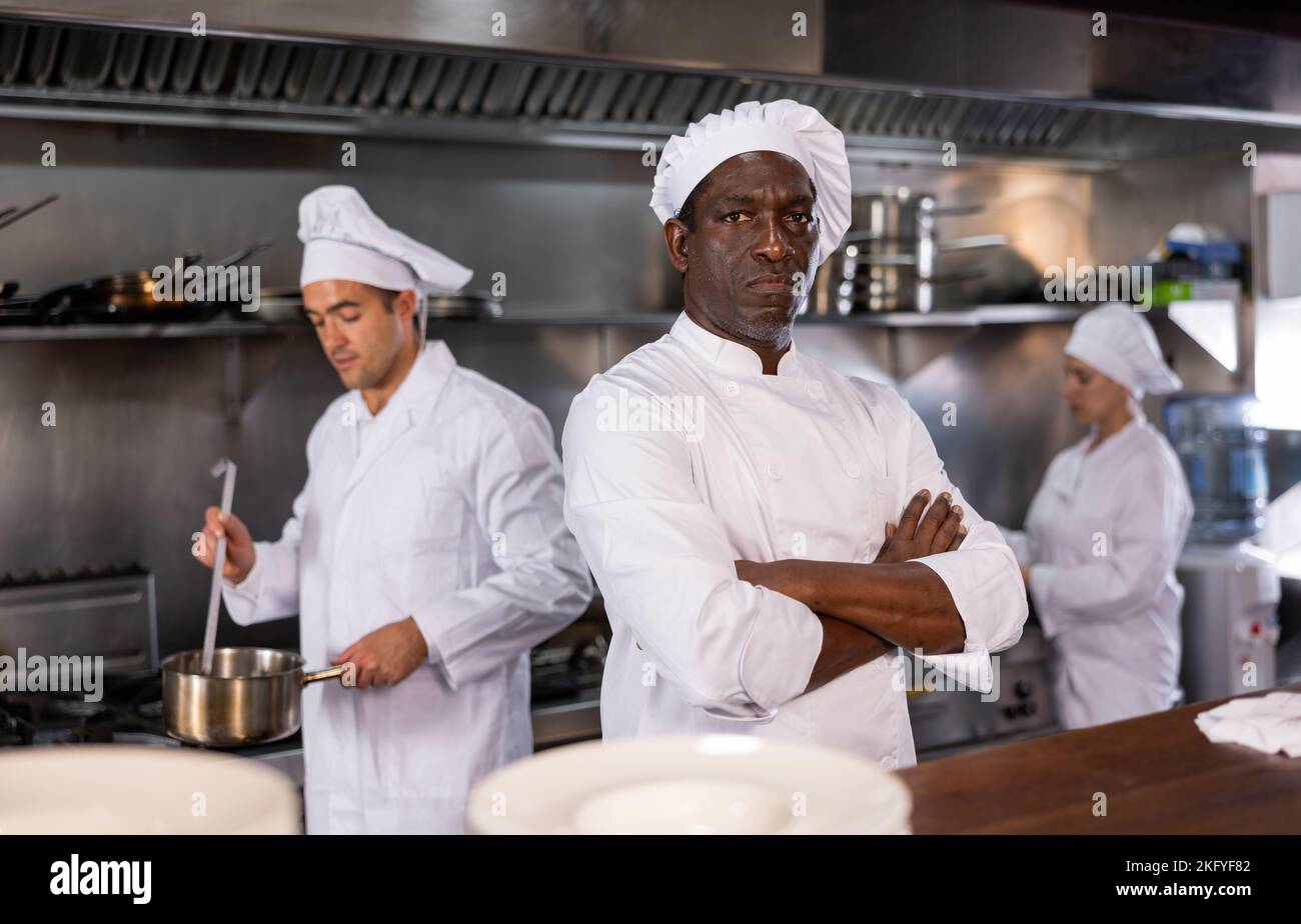 Man head chef posing in restaurant kitchen Stock Photo - Alamy