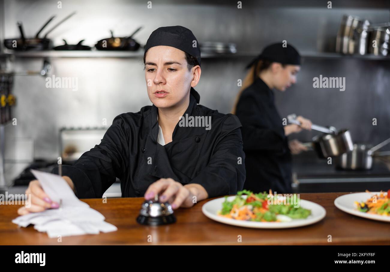 Chef checking orders and giving out meal Stock Photo - Alamy