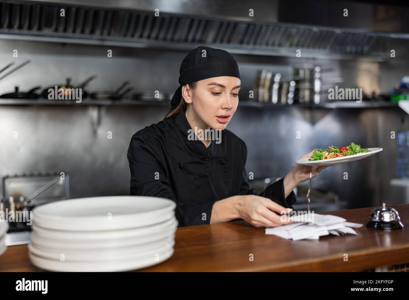 Woman cook checks paid check and cooked dish in kitchen Stock Photo - Alamy