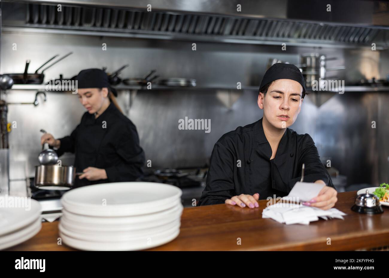 Chef checking orders and giving out meal Stock Photo - Alamy
