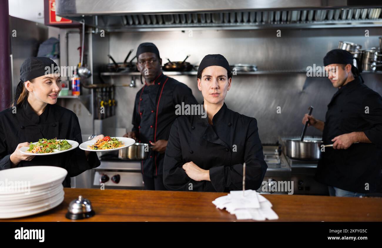 Woman head chef posing in restaurant kitchen Stock Photo - Alamy