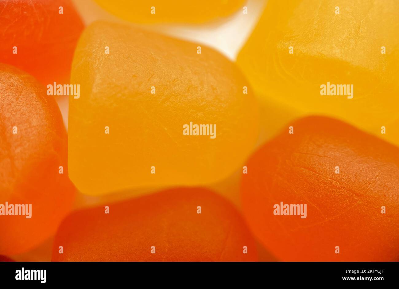 Close-up texture of orange and yellow multivitamin gummies on white ...
