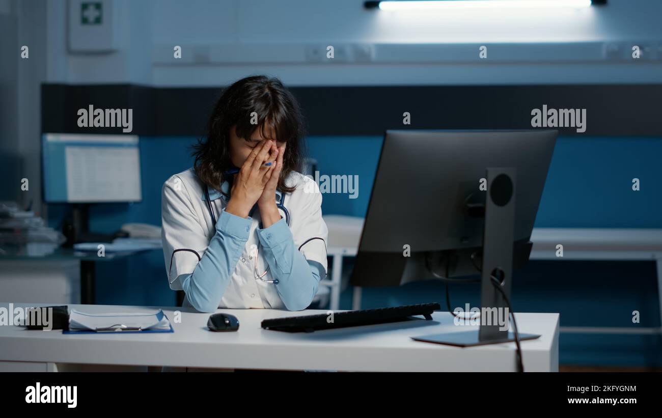 Tired exhausted physician woman working late at night in hospital ...