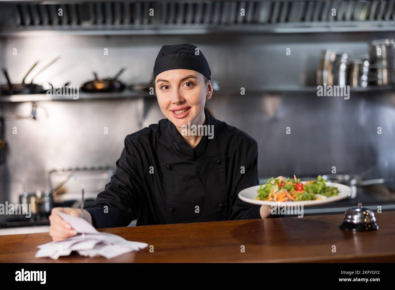Woman cook checks paid check and cooked dish in kitchen Stock Photo - Alamy