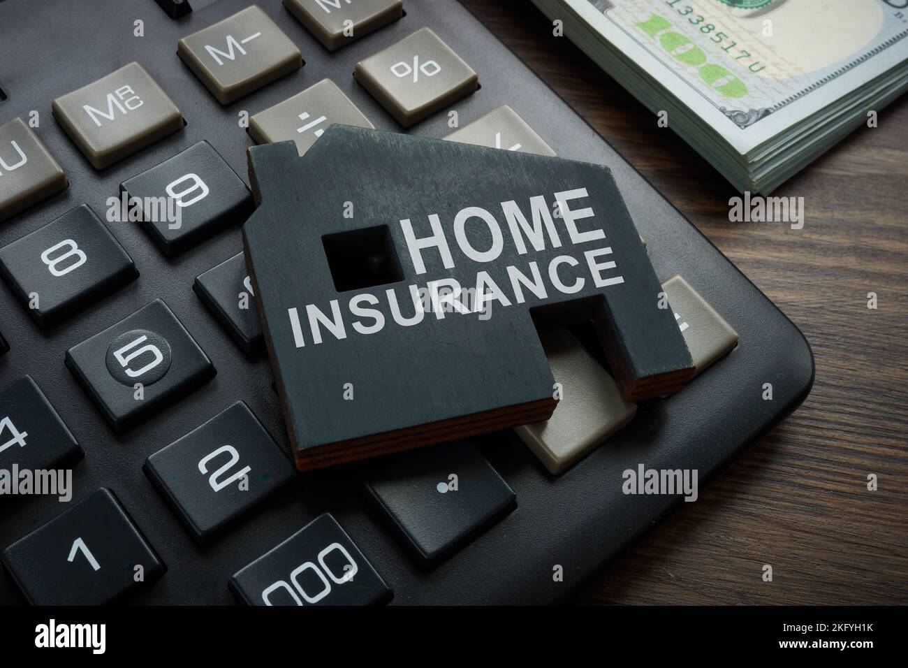 Calculator and wooden house with sign home insurance Stock Photo - Alamy