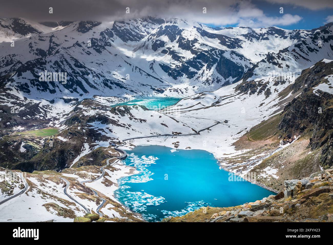Alpine lake and mountain road at springtime, Gran Paradiso Alps, Italy ...