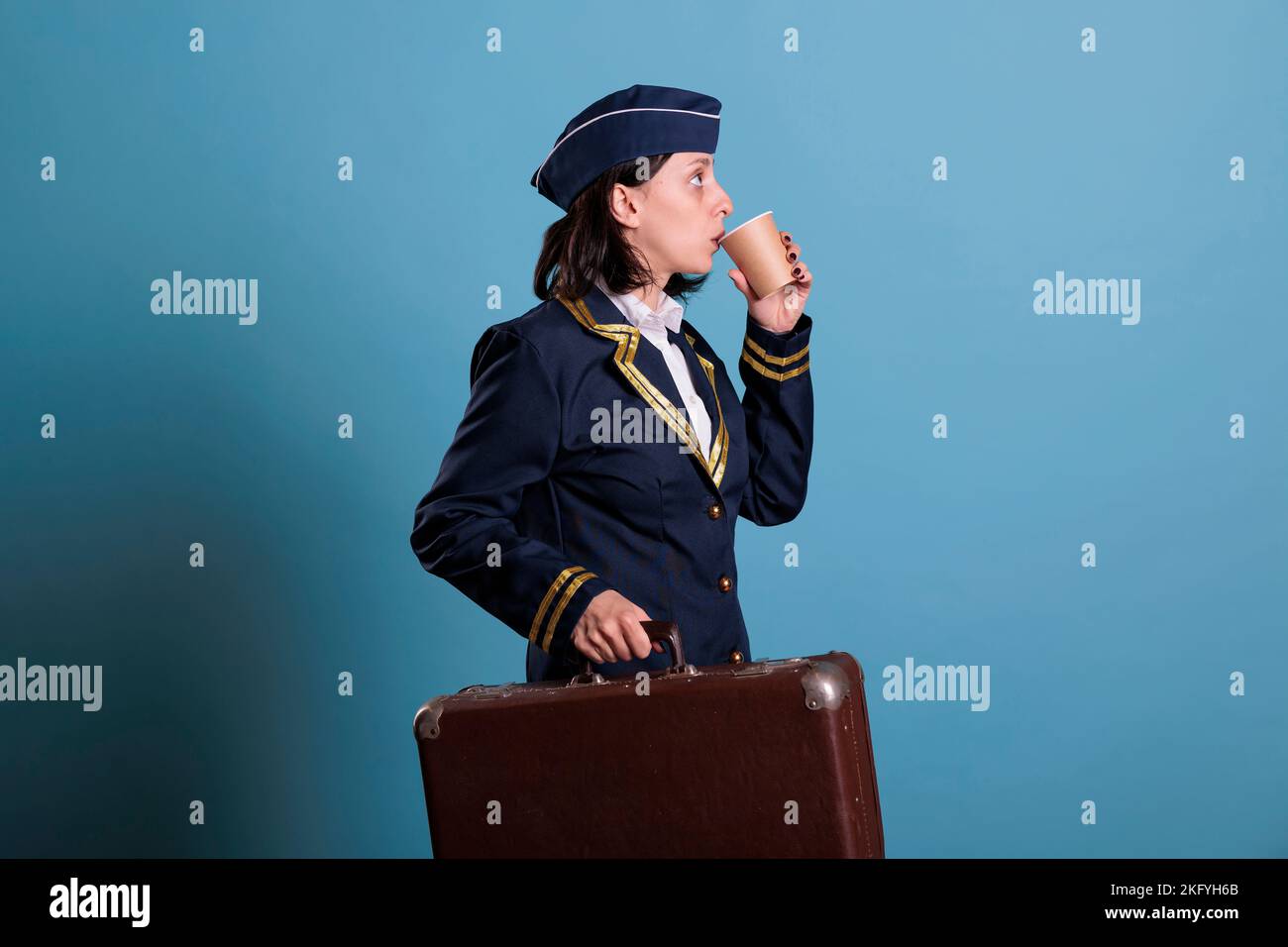 Stewardess in professional airline uniform carrying baggage, while ...