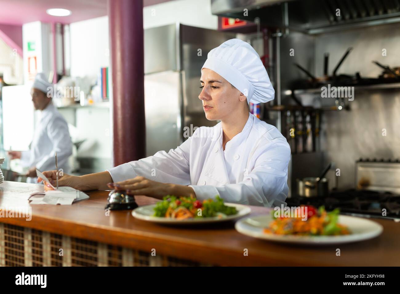 Chef checking orders and giving out meal Stock Photo - Alamy