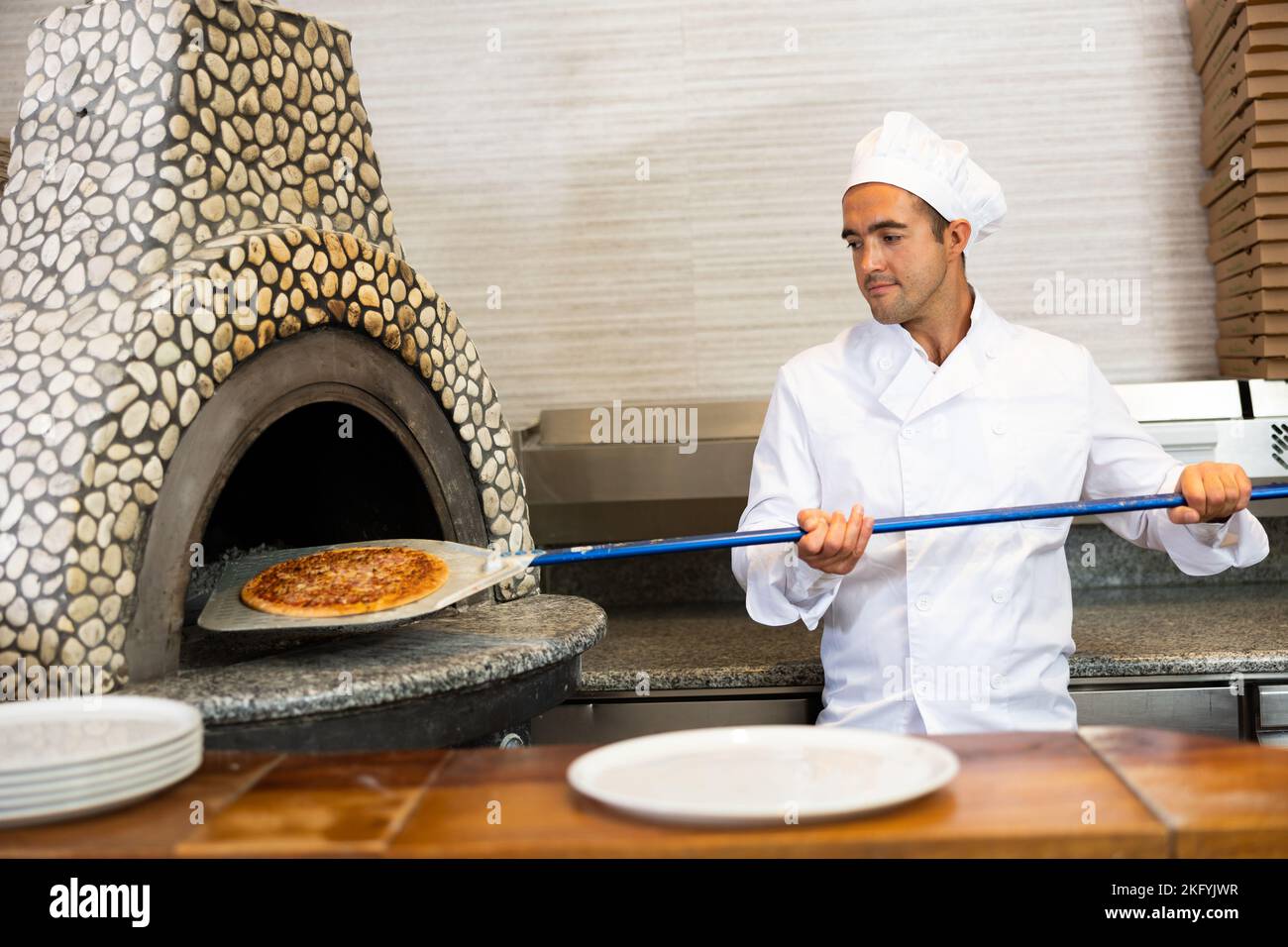 Skilled man chef preparing pizza in restaurant Stock Photo - Alamy