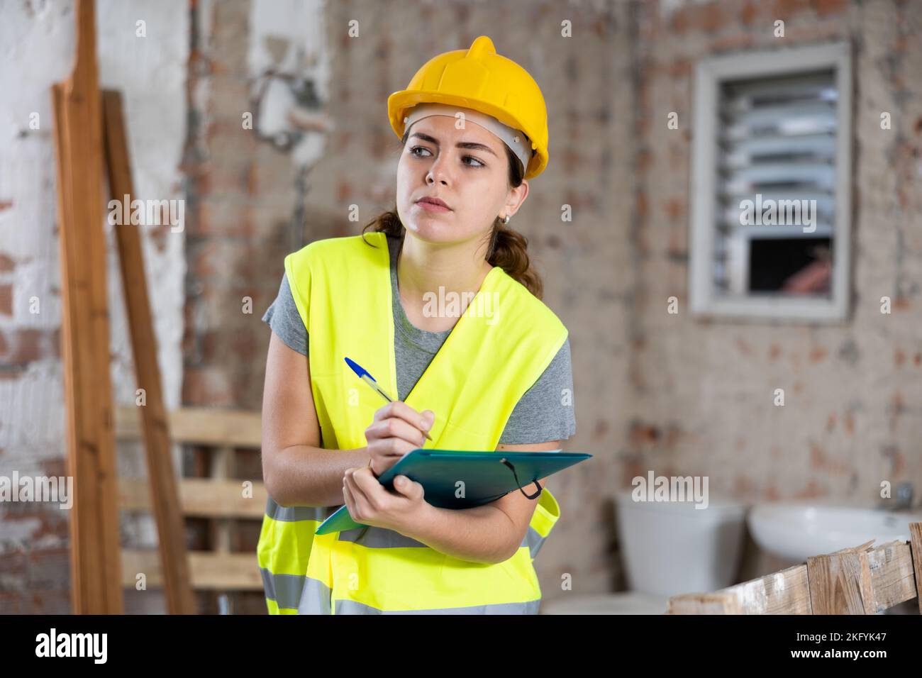 Female civil engineer making notes while controlling construction site ...