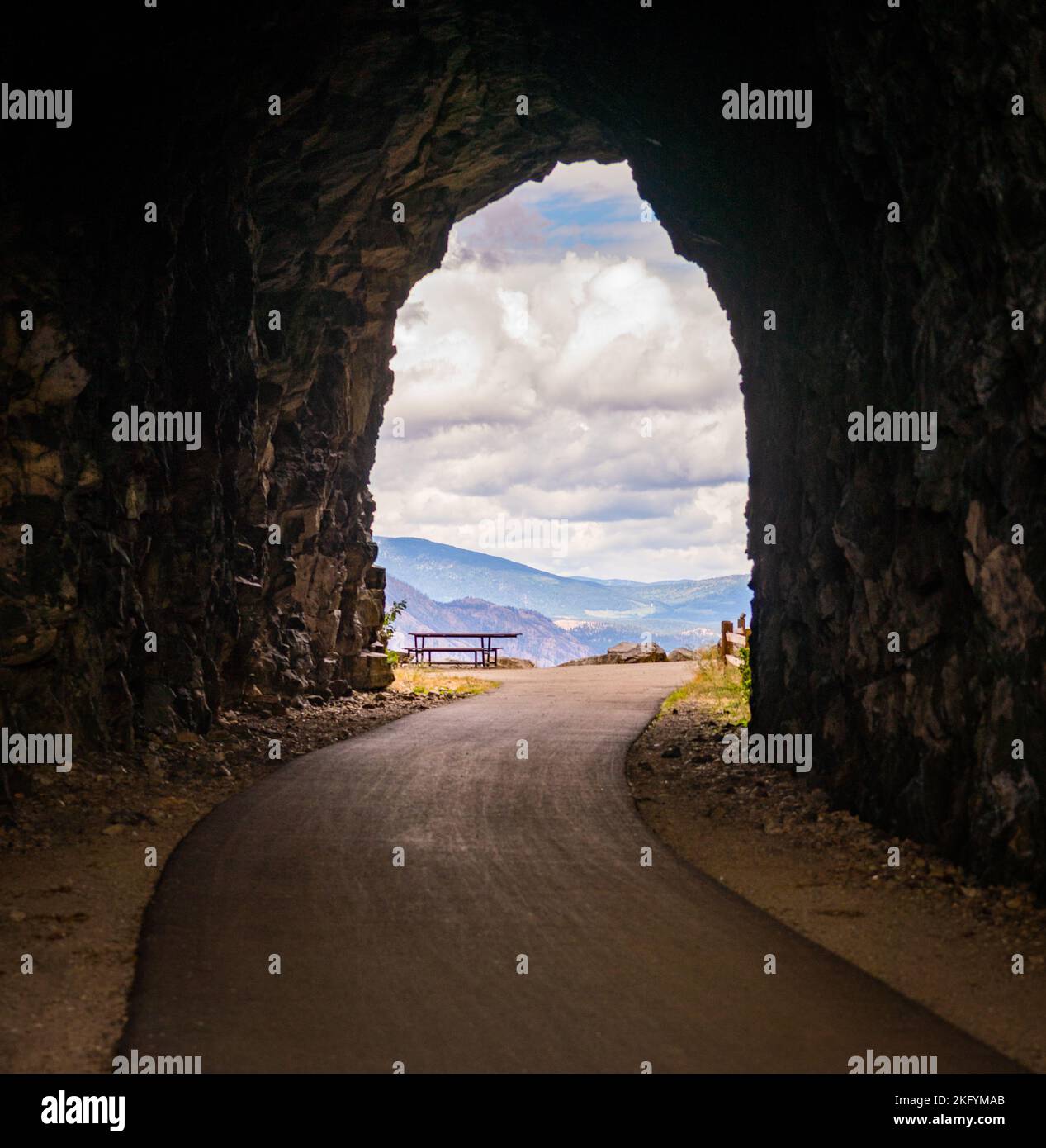 Tunnel showing new landscape outside of path Stock Photo - Alamy
