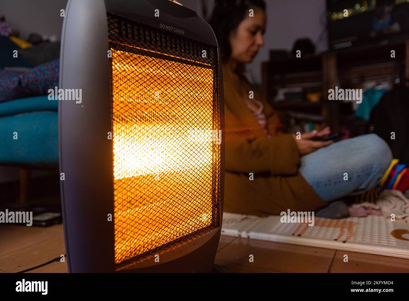 Barcelona, Spain. 20th Nov, 2022. A woman is seen seated next to an electric heater at home ...