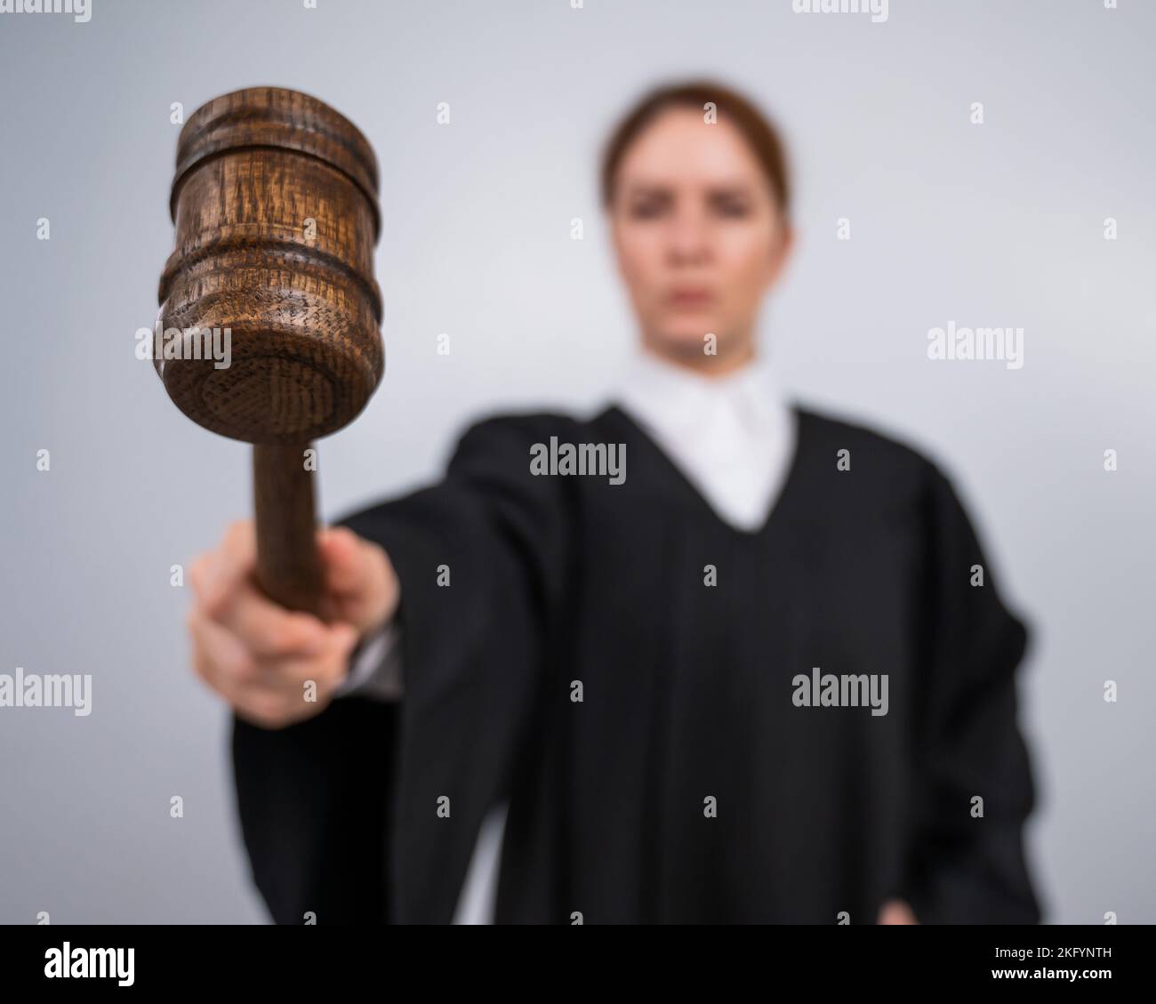 Steadfast female judge in a robe holding a court gavel Stock Photo - Alamy