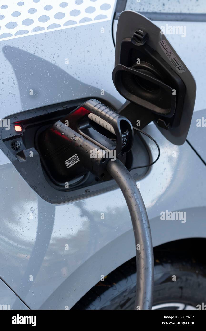 A close-up of an electric car charging plug connected to a car Stock ...