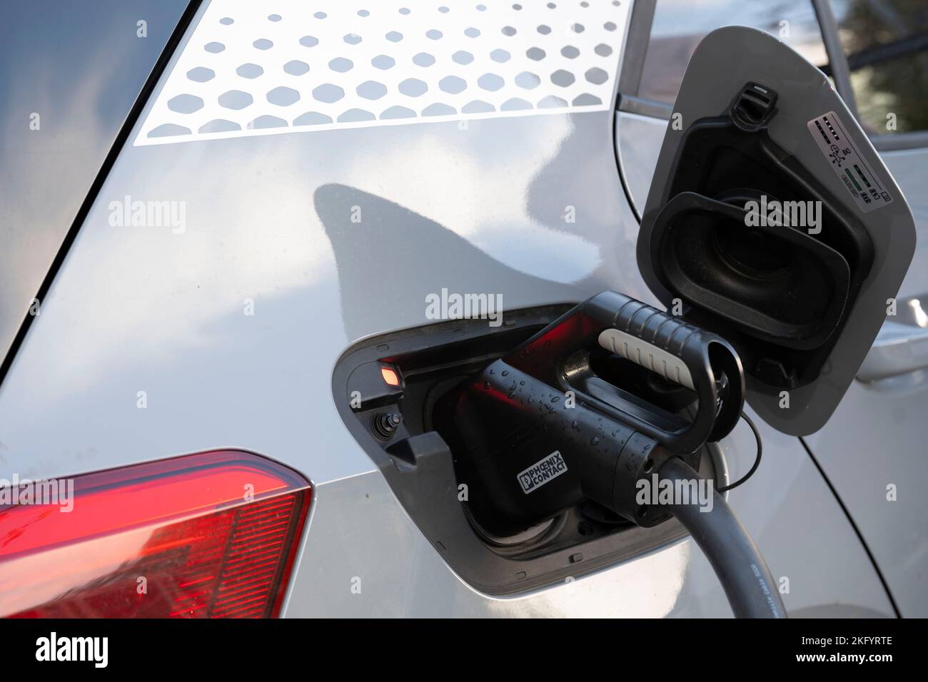 A close-up of an electric car charging plug connected to a car Stock ...