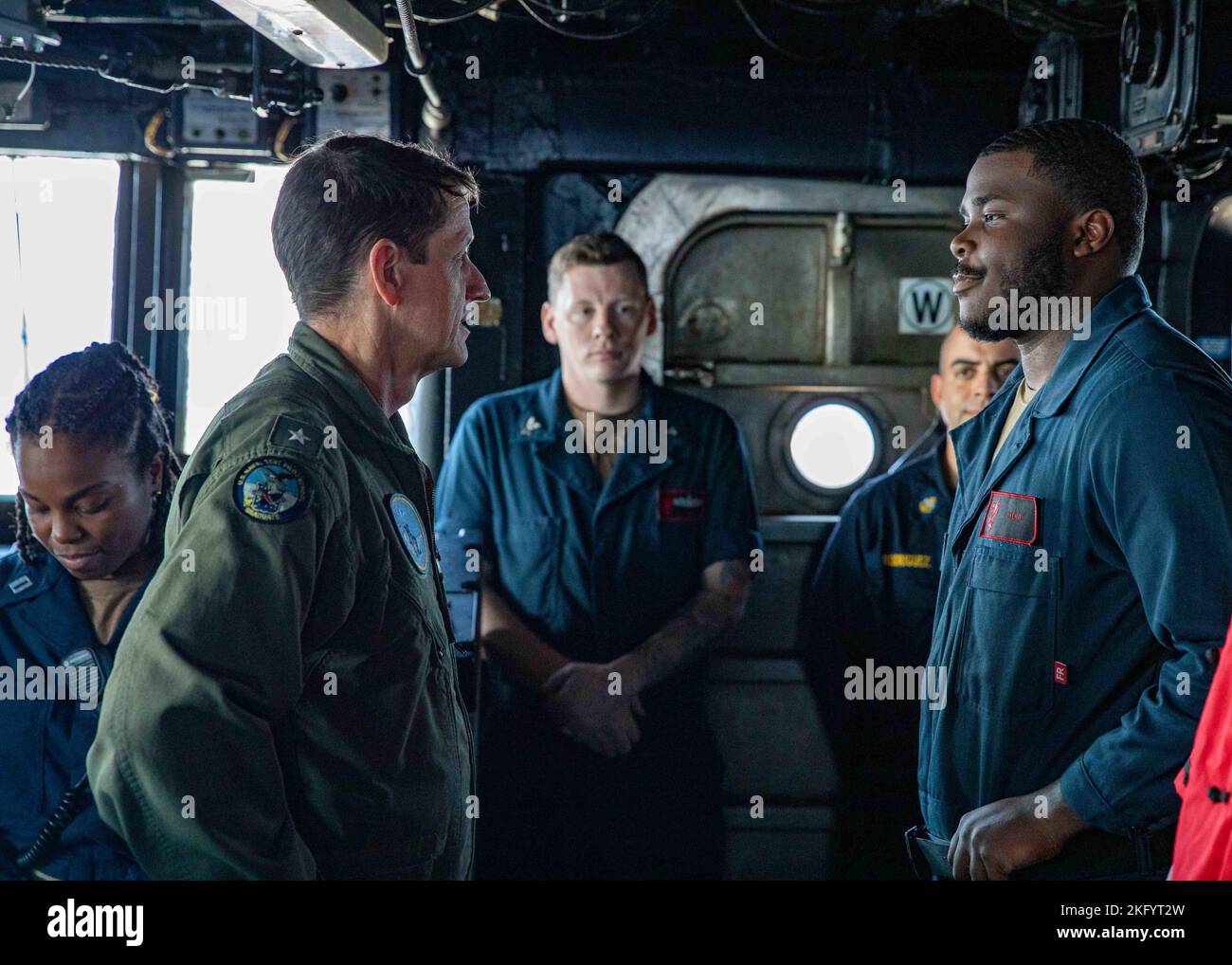Rear Adm. Greg Huffman, Commander, Carrier Strike Group 12, left, talks ...