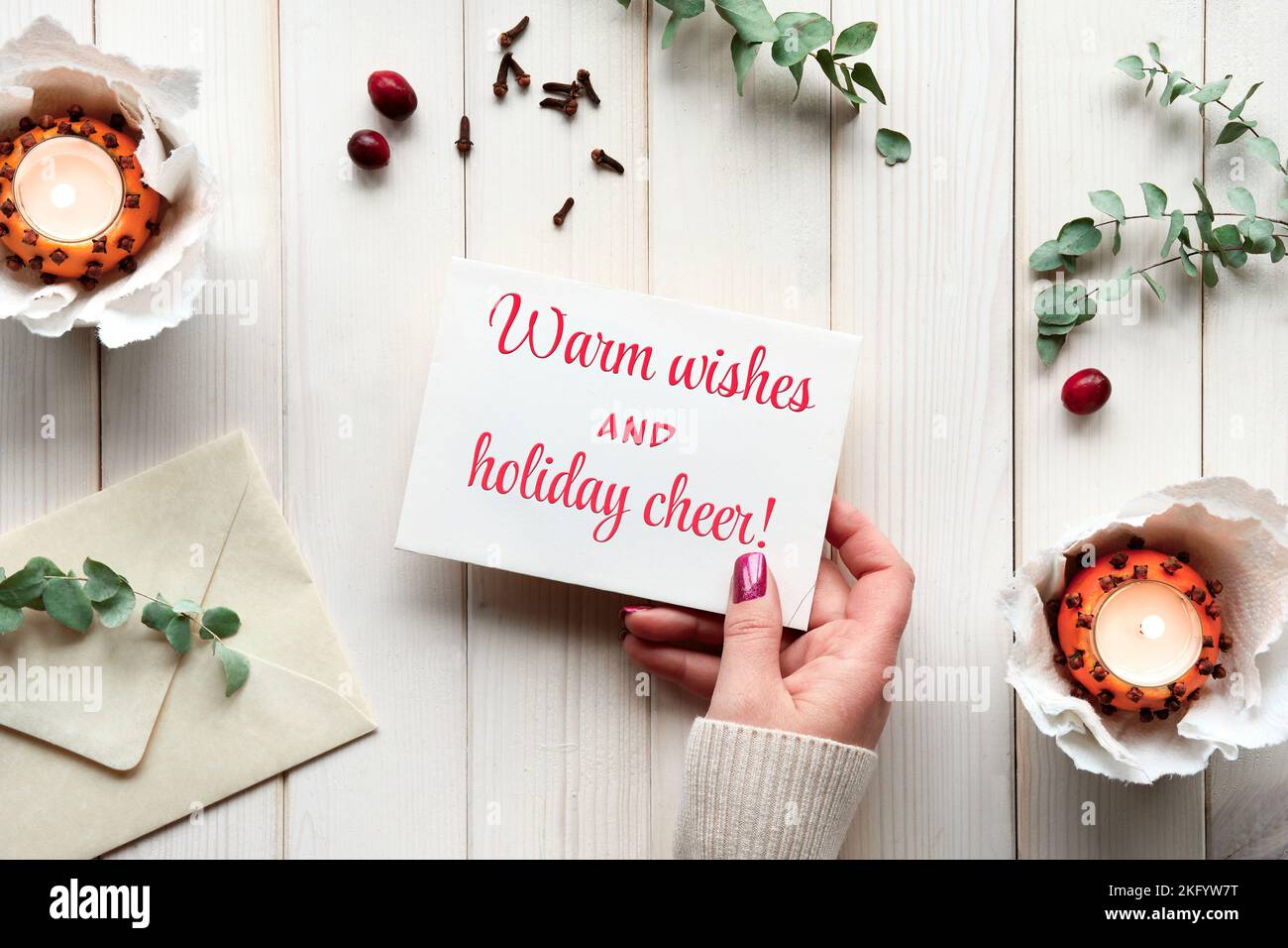 Winter holiday greeting card with caption text in hand. Eucalyptus, tea ...