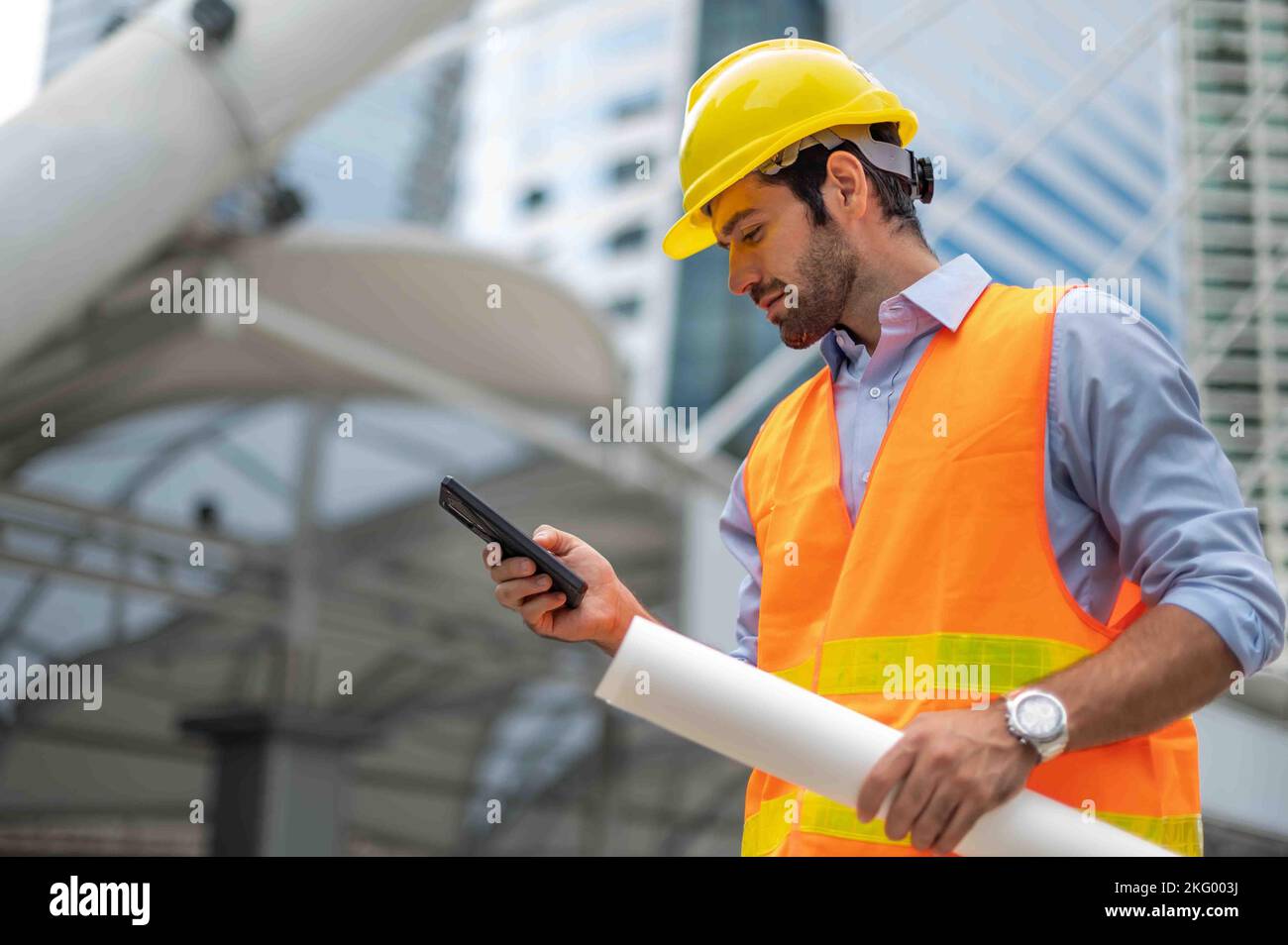 Caucasian man engineers use a smartphone for talking, wearing an orange ...