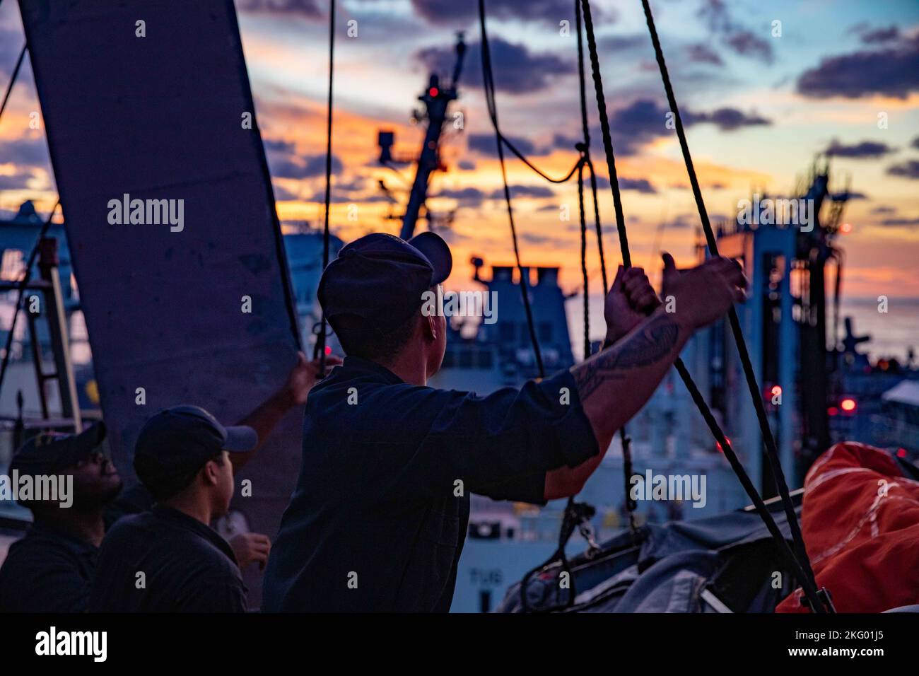 Quartermaster 3rd Class Jeremiah Patao, center, assigned to the Arleigh ...