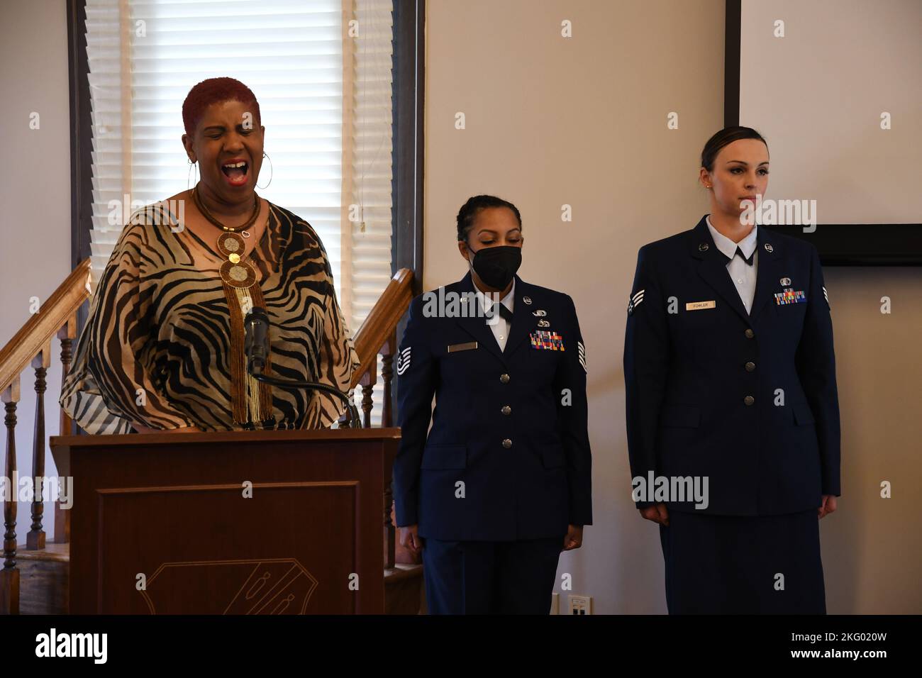 Tracey Buckner sings the national anthem before Master Sgt. Jacqueline ...