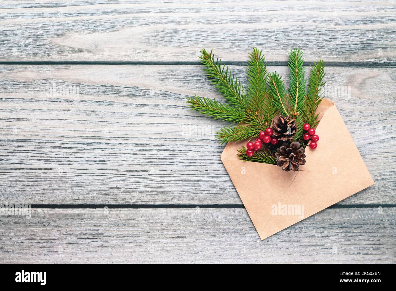 Christmas tree twigs in paper envelope on wooden background, eco ...