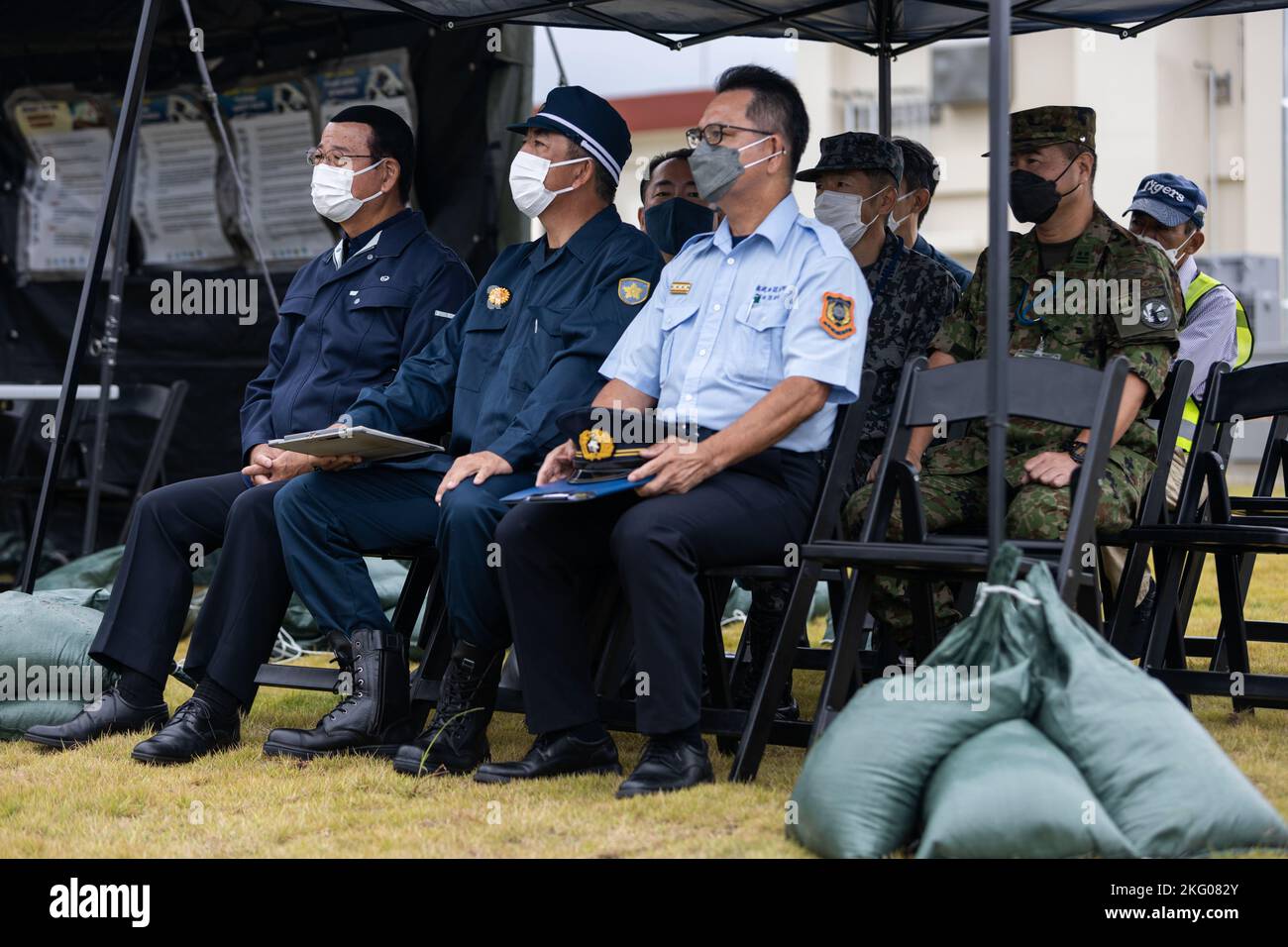Observers listen to a brief at a tsunami evacuation drill during ...