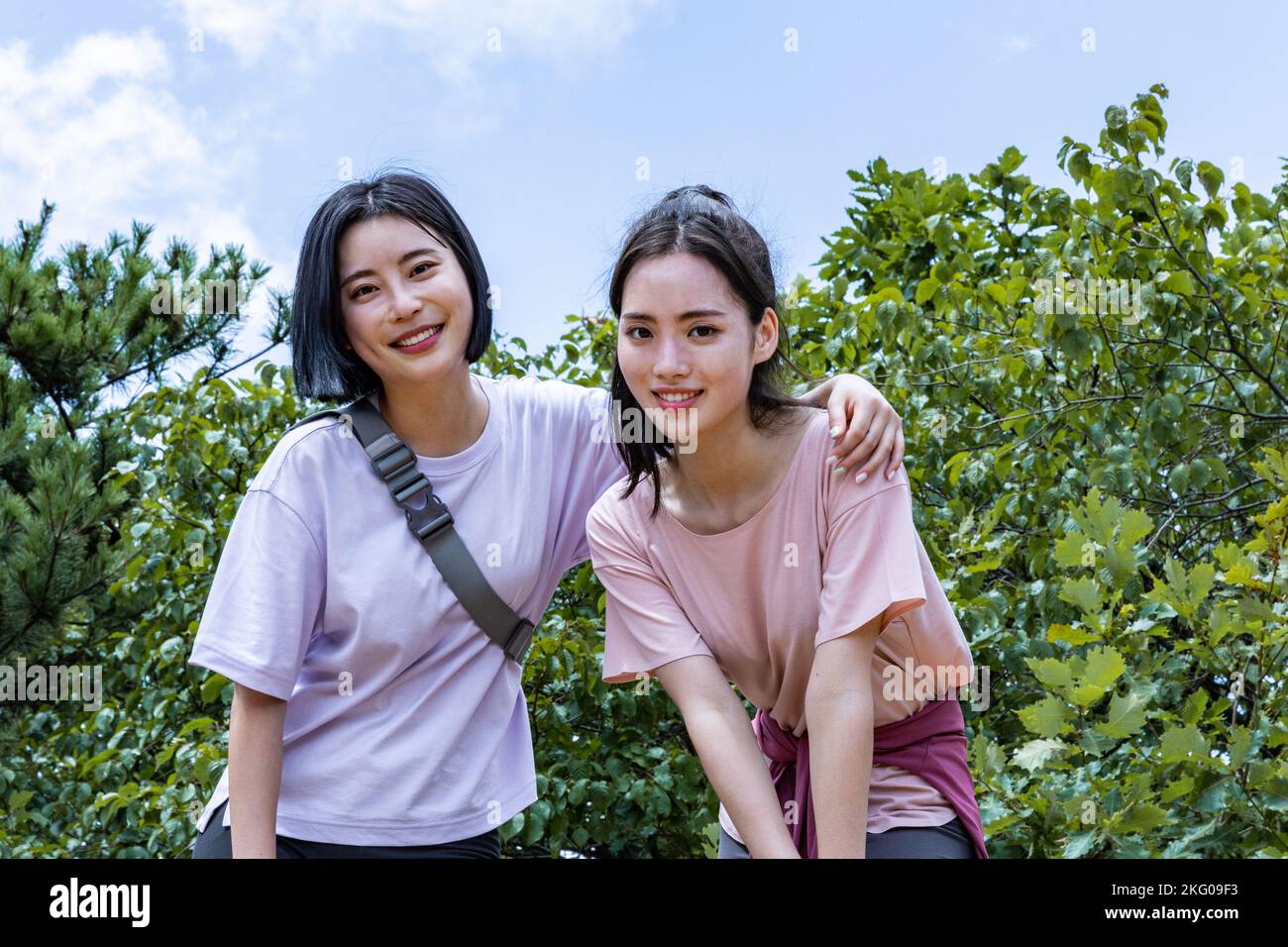korean young women hiking and plogging putting arms around each other;s ...
