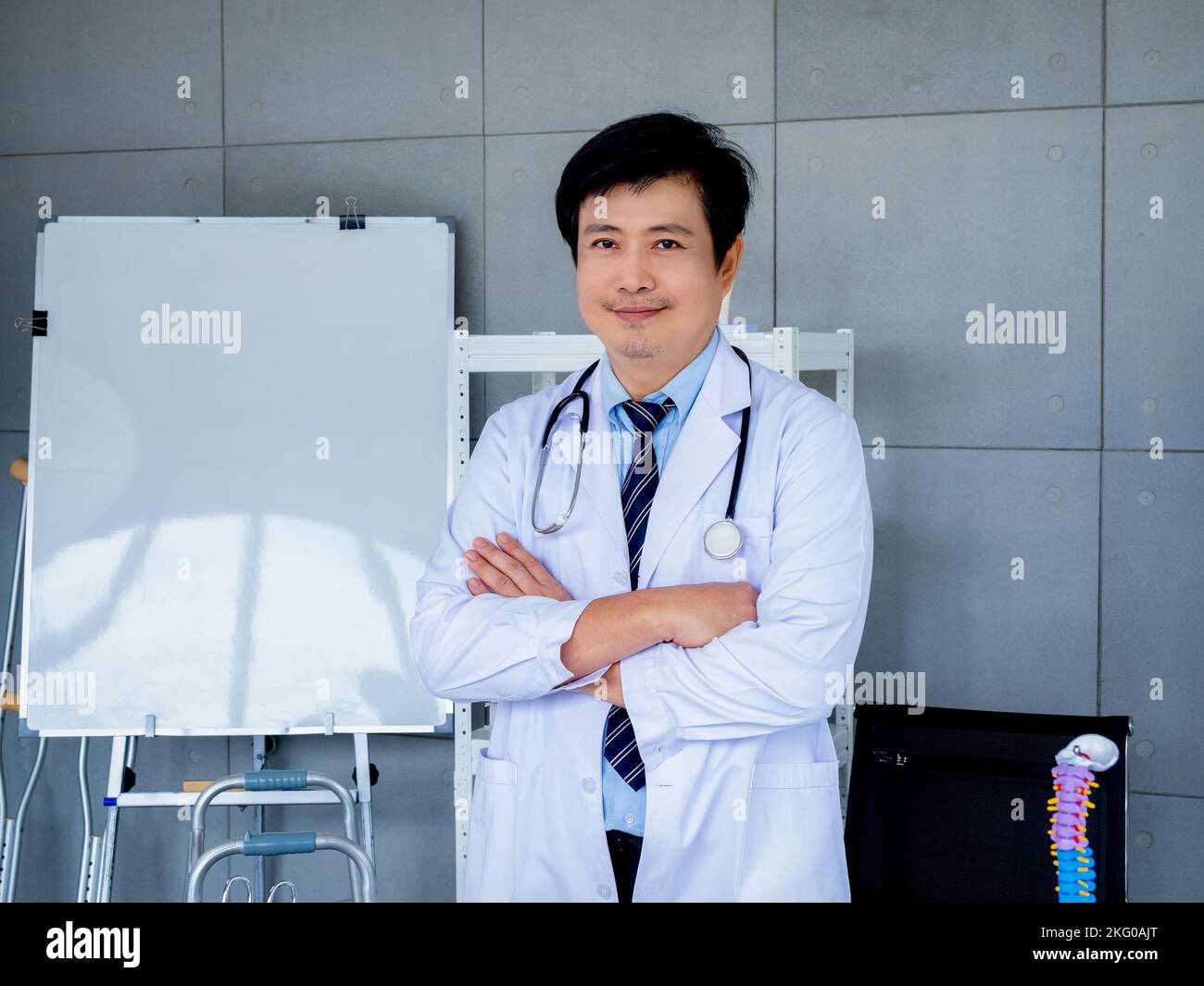 Smiling Asian man orthopedic doctor portrait in white coat standing ...