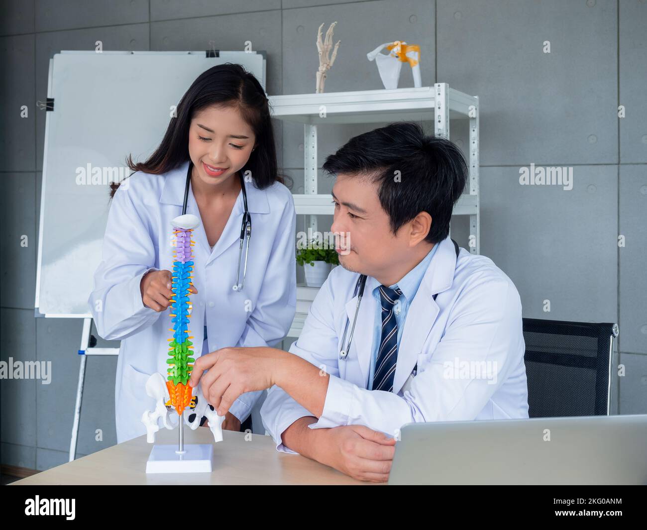 Two Asian doctors in white uniforms talking and working together in ...