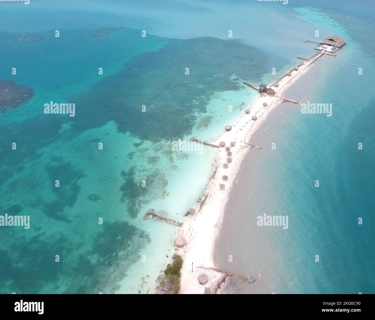 A scenic bird's eye view of a sandy path surrounded by turquoise water ...