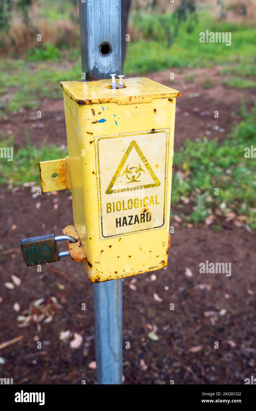 A free sharps (syringes) deposit container in a park in outside a ...