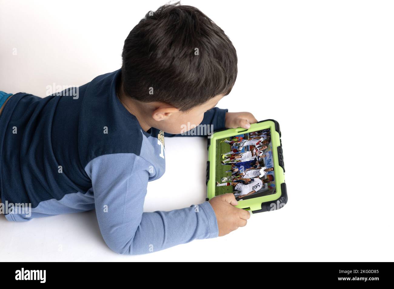 Child lying on the floor watching a football game on his tablet Stock ...