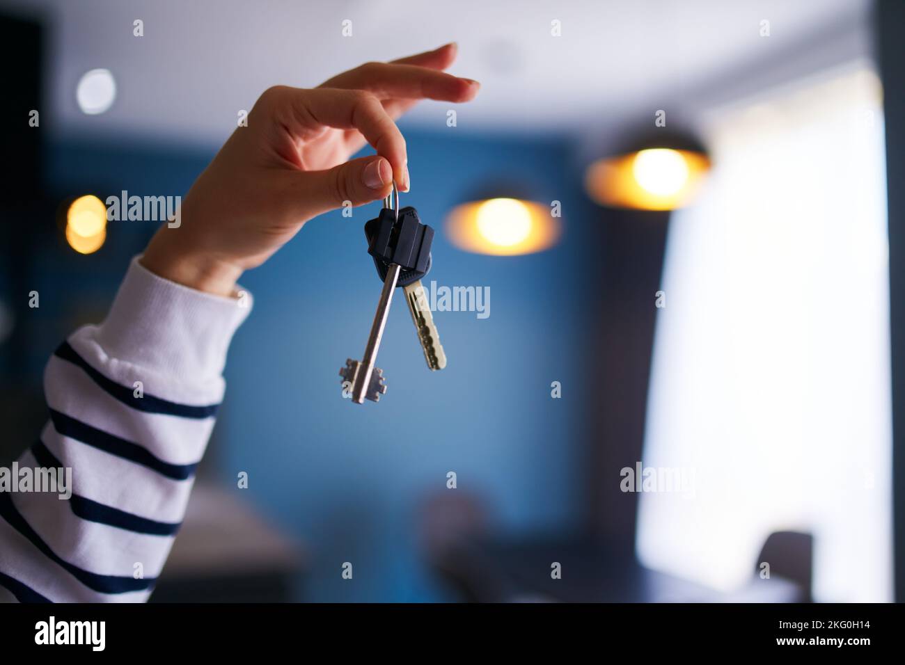 Close up of female hand showing new house or apartment key to camera on ...