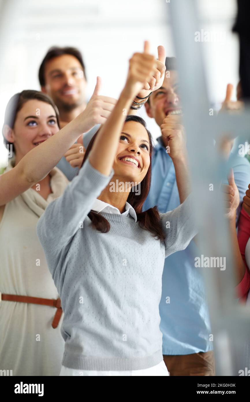Showing their approval. A group of colleagues looking up and showing ...