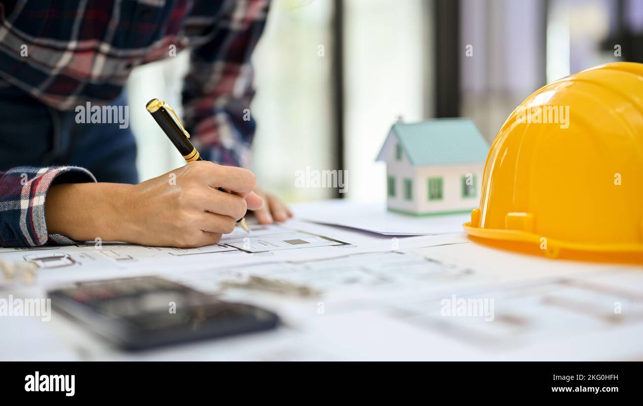 Professional Asian female engineer or architect taking notes on paper ...