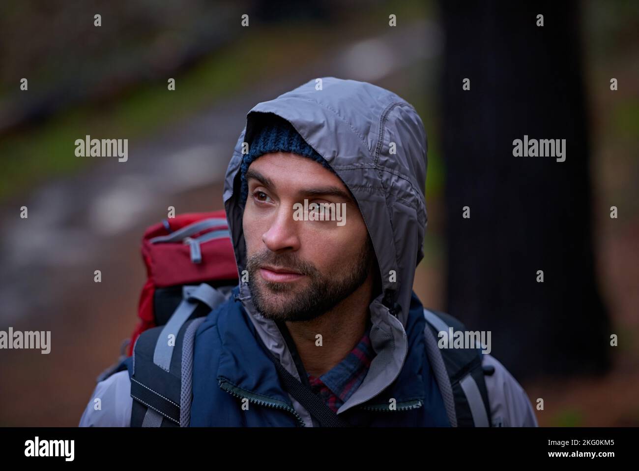 All-weather nature fanatic. Portrait of a young man wearing a backpack ...